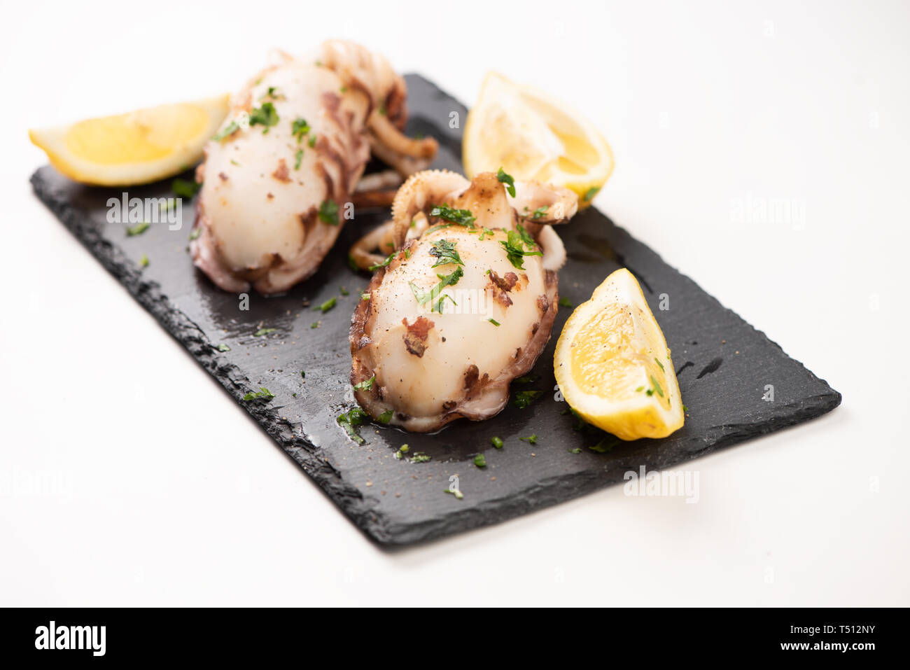 Delicious BBQ cuttle fish on a stone dish isolated on white Stock Photo ...