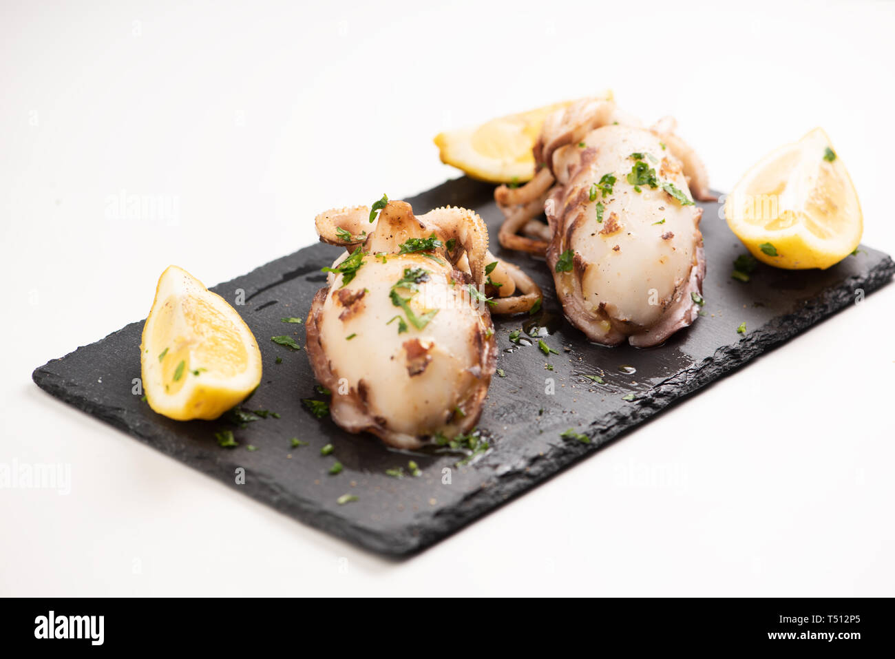 Delicious BBQ cuttle fish on a stone dish isolated on white Stock Photo ...