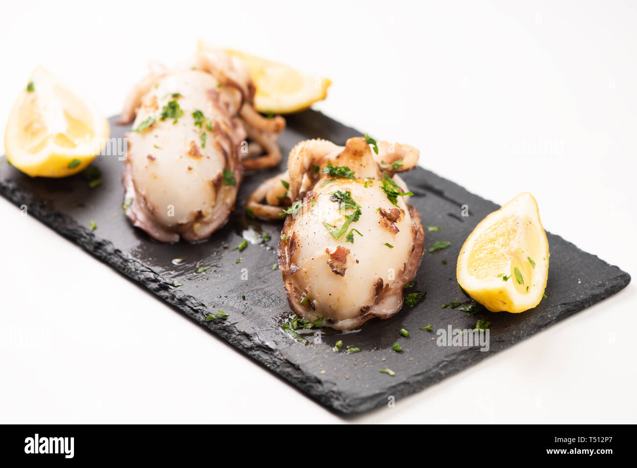 Delicious BBQ cuttle fish on a stone dish isolated on white Stock Photo ...