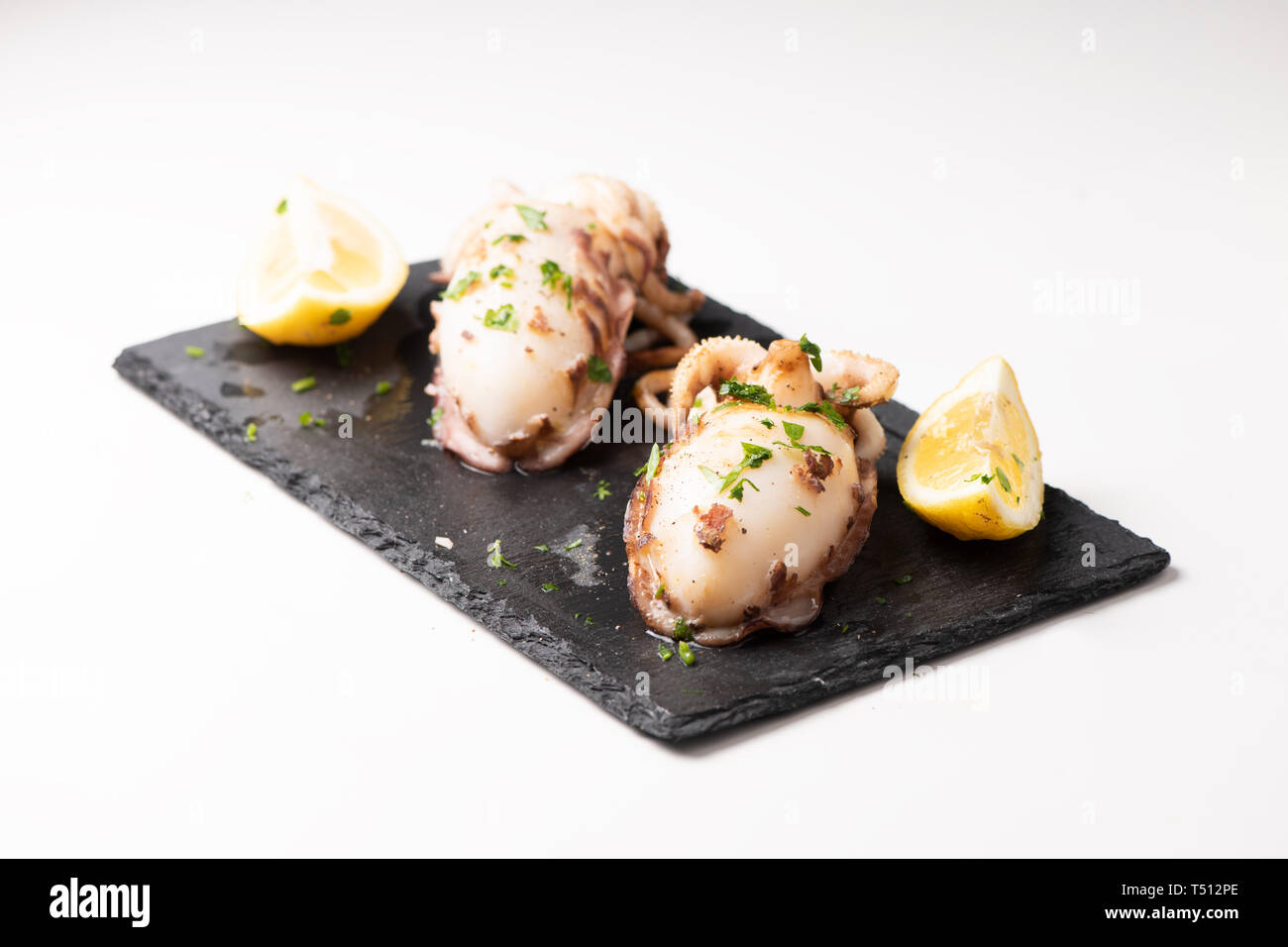 Delicious BBQ cuttle fish on a stone dish isolated on white Stock Photo ...