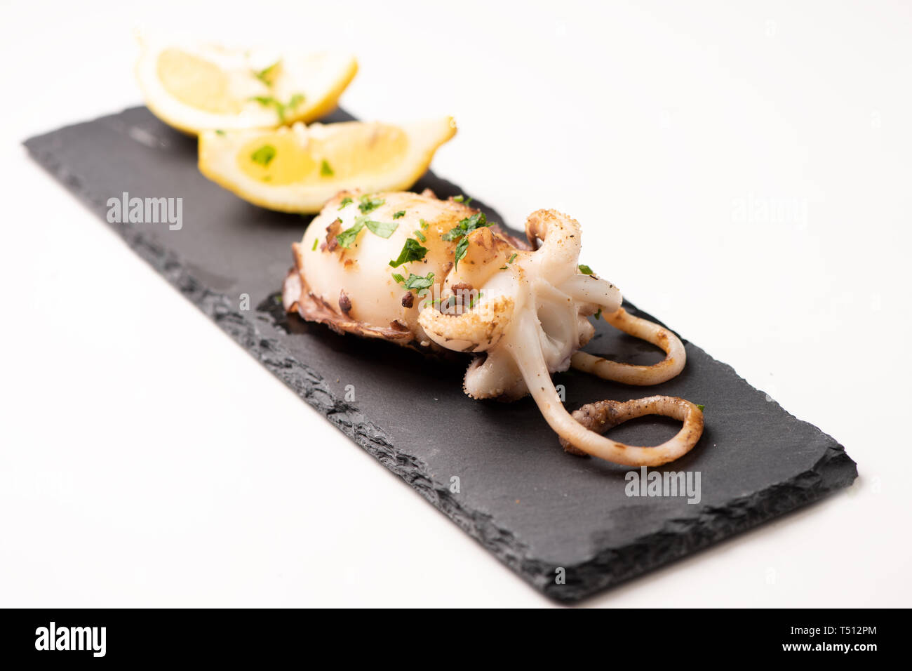 Delicious BBQ cuttle fish on a stone dish isolated on white Stock Photo ...