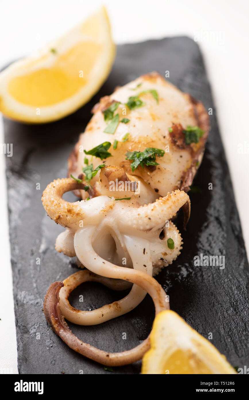 Delicious BBQ cuttle fish on a stone dish isolated on white Stock Photo ...