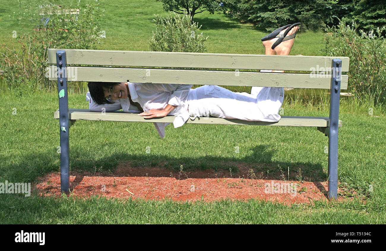 Woman reclining wooden bench outdoors hi-res stock photography and ...