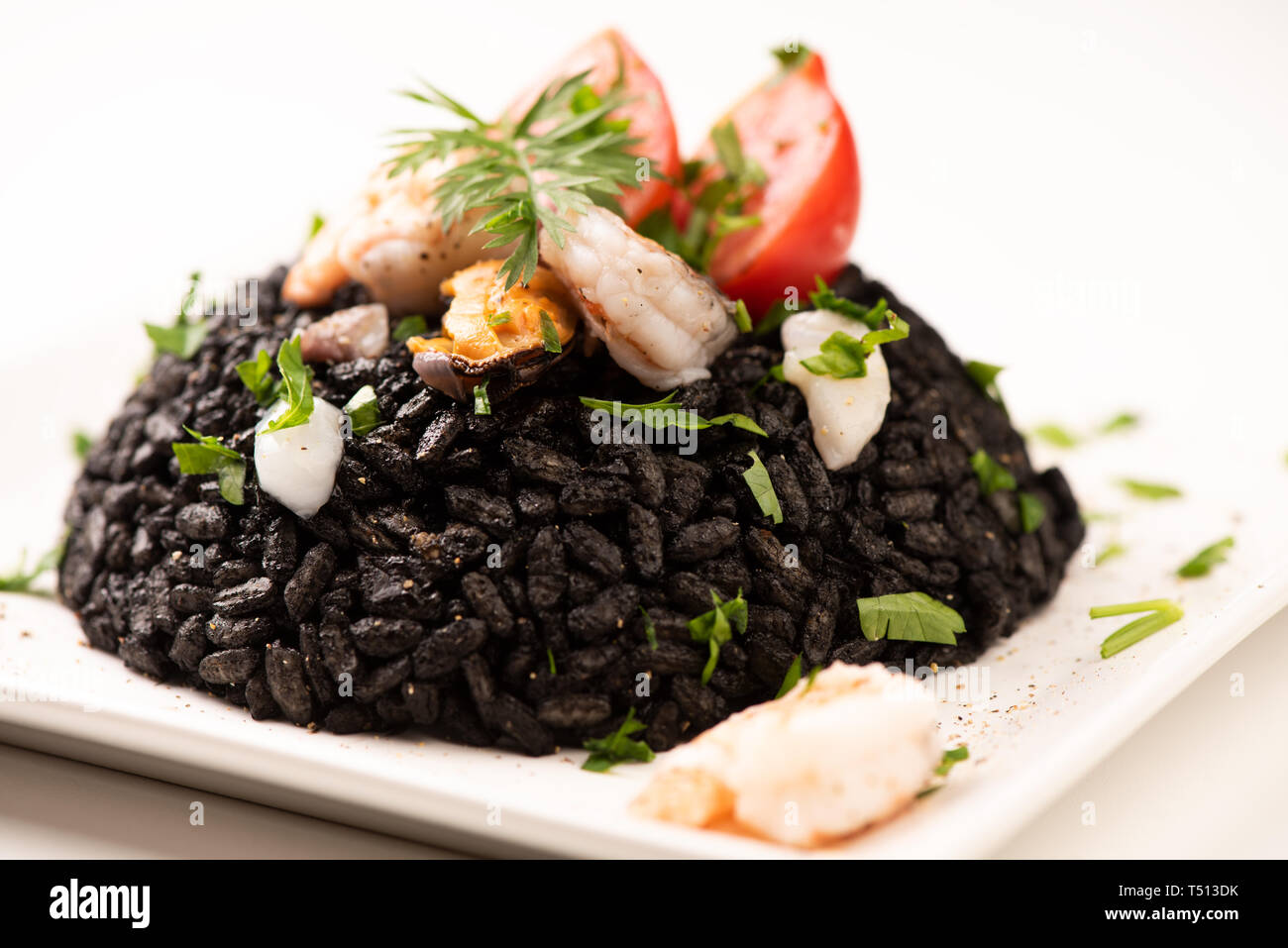 Black rice with cuttlefish on white background close up Stock Photo - Alamy