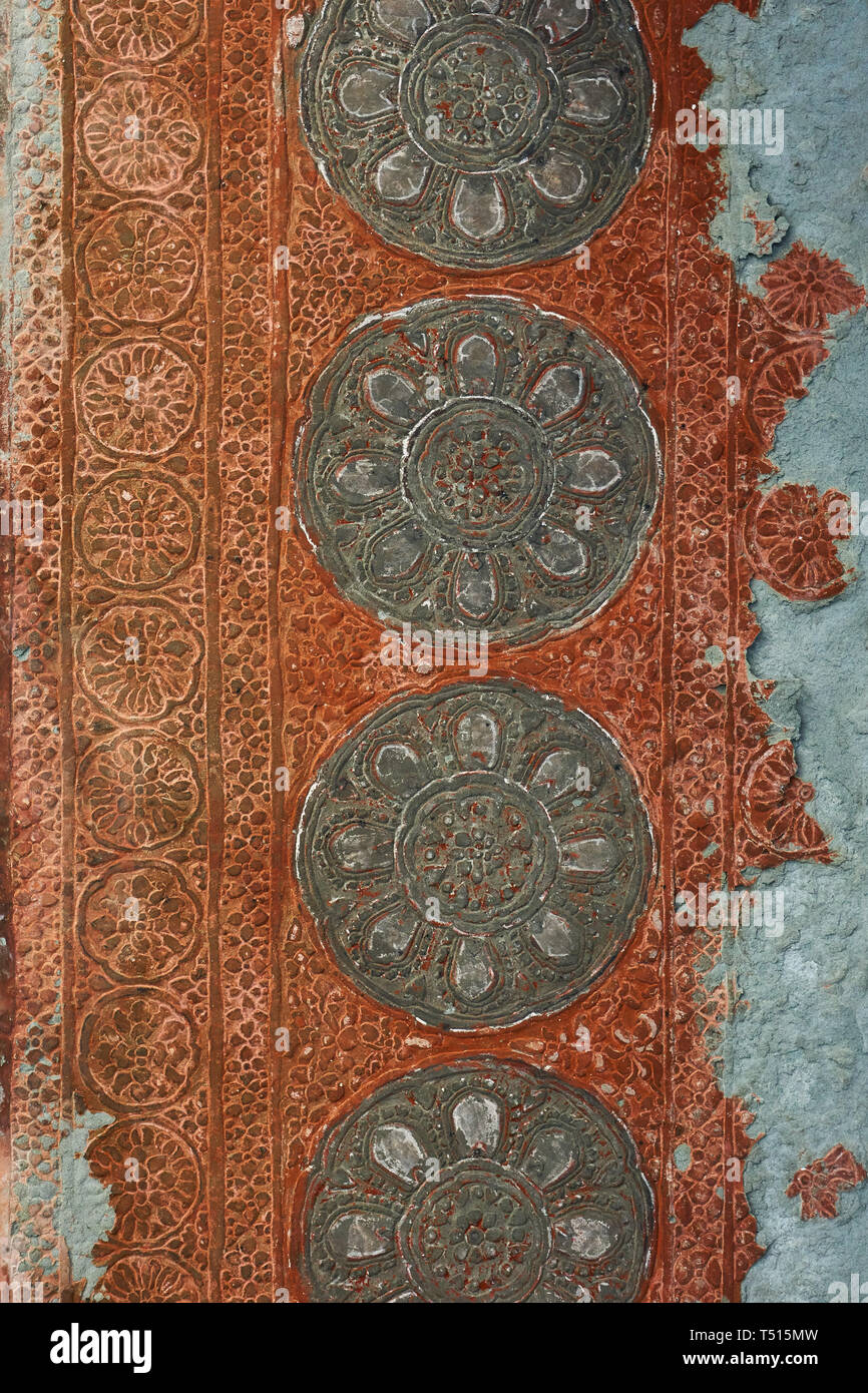 Rust-red and gray (grey) circular patterns (medallions) engraved on a ...