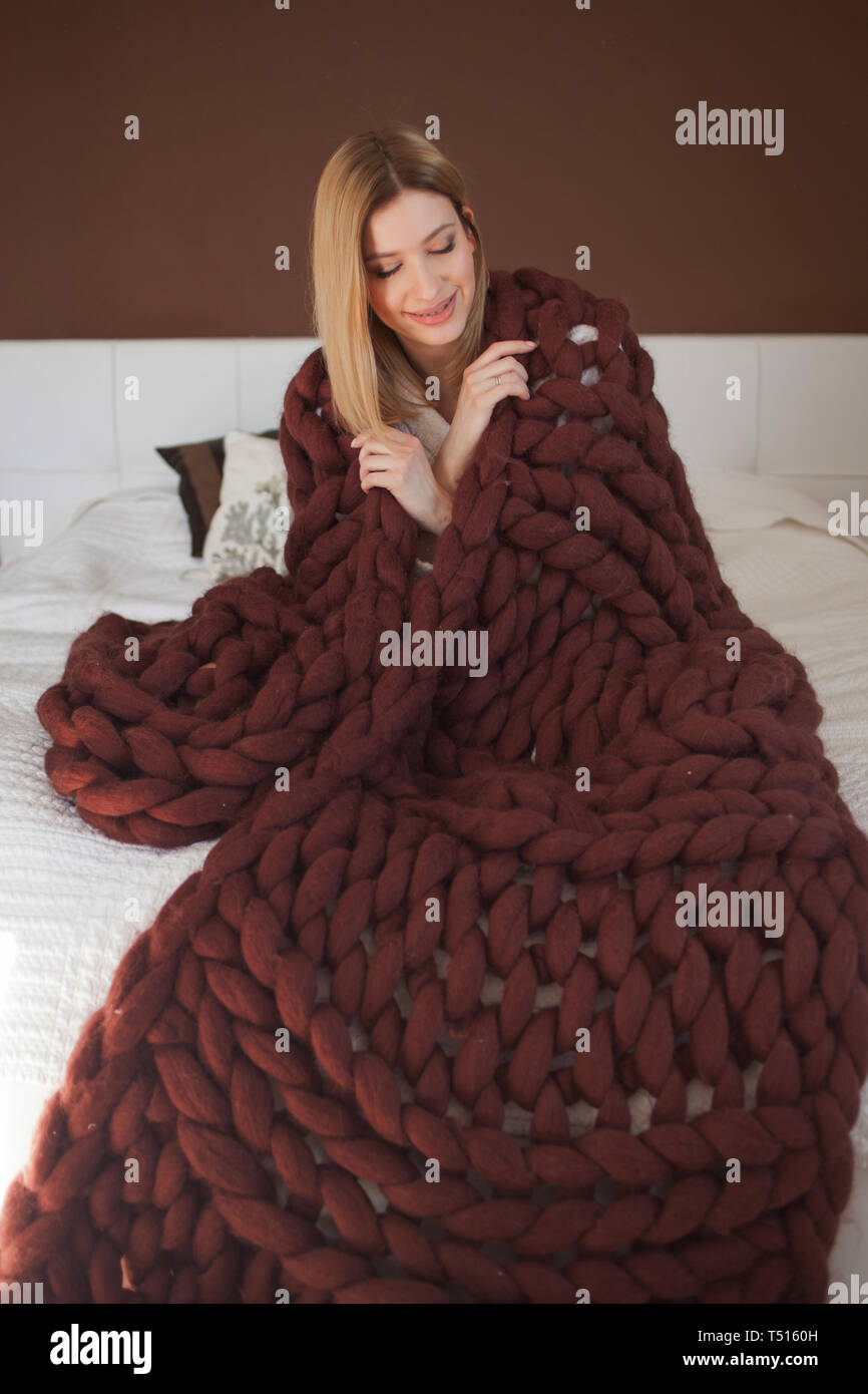 An attractive young woman is wrapped in a soft fluffy blanket. Girl ...