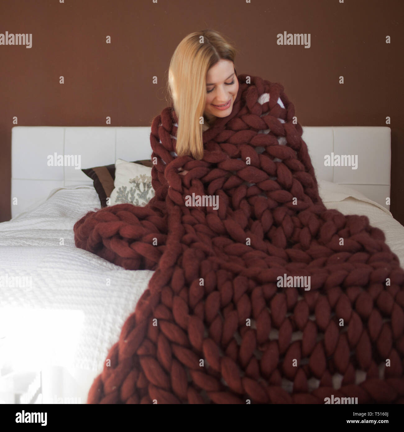An attractive young woman is wrapped in a soft fluffy blanket. Girl ...