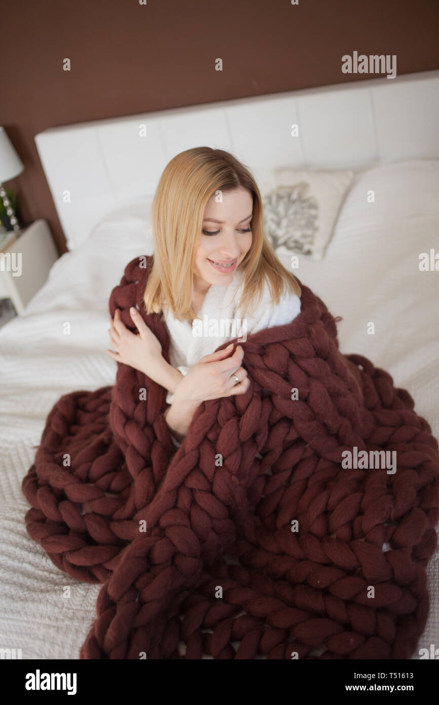 An attractive young woman is wrapped in a soft fluffy blanket. Girl ...