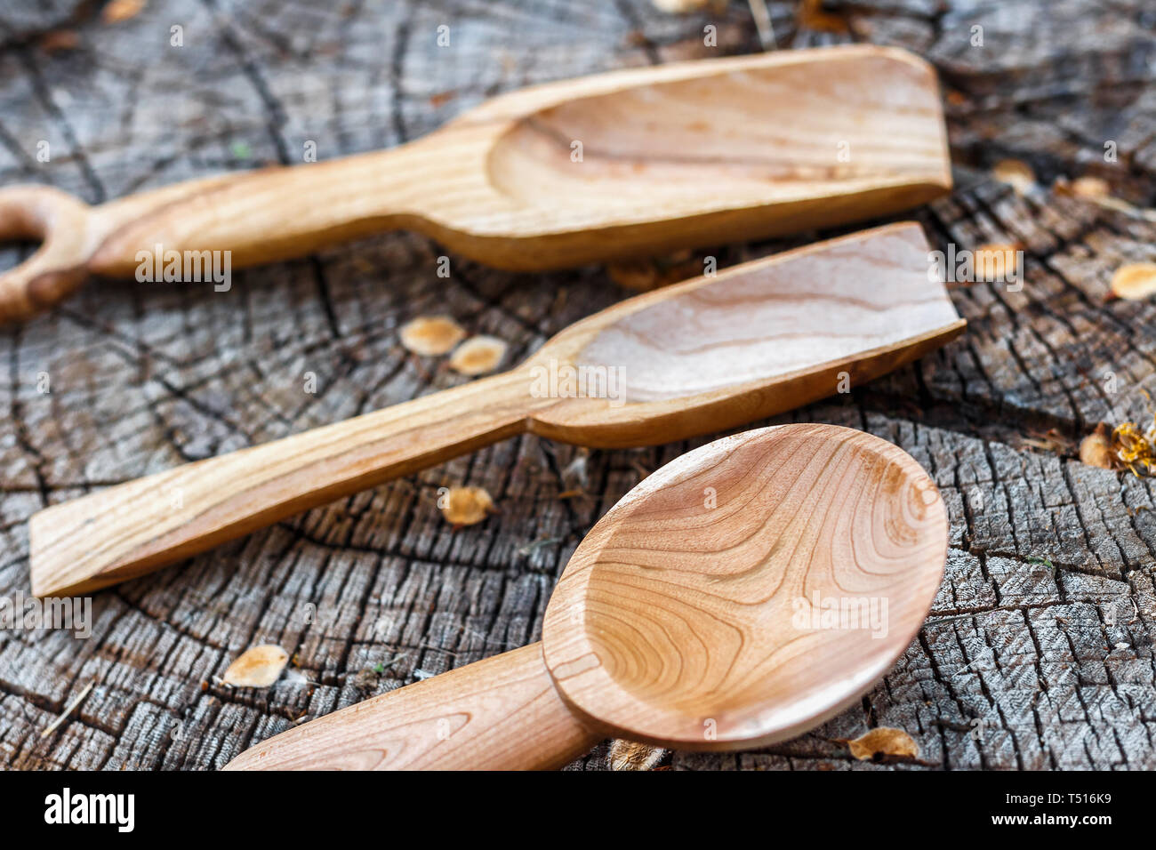 Handmade rustic wooden spoons from beautiful wood on a stump. Focus on ...