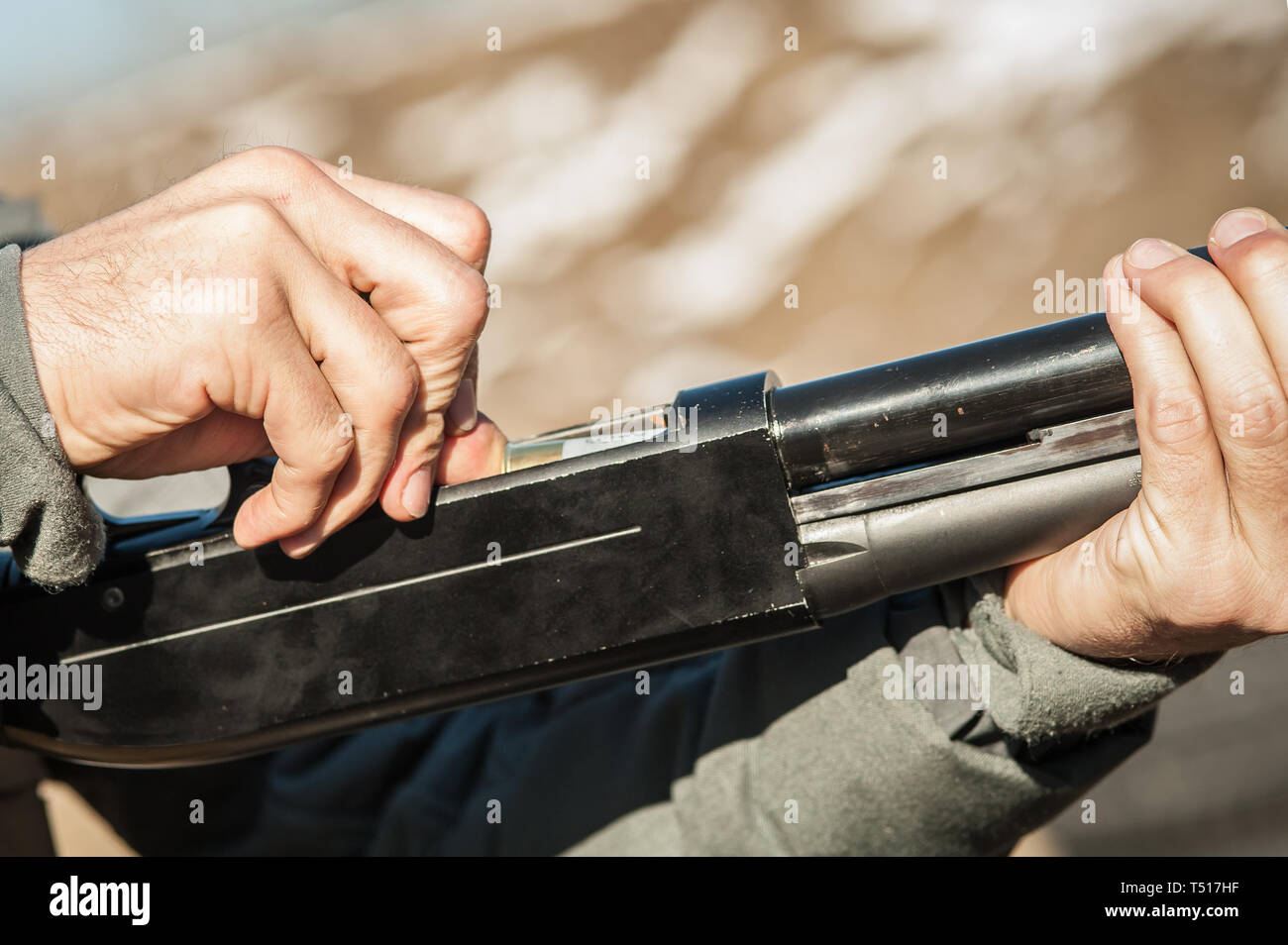 Close-up top macro view of soldier hands load shotgun bullets patrons ...