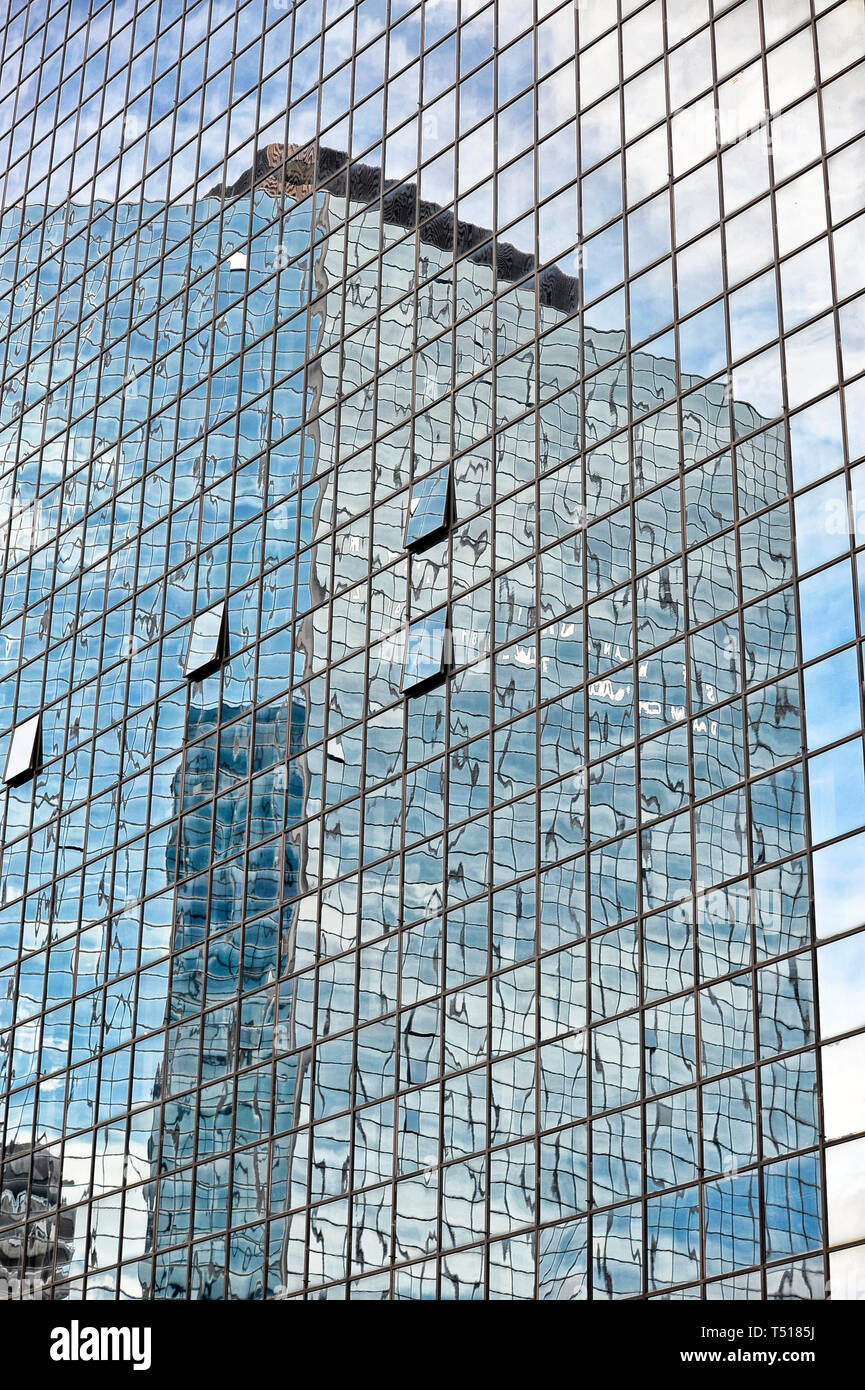 Blue glass wall of a modern skyscraper reflecting other buildings Stock ...