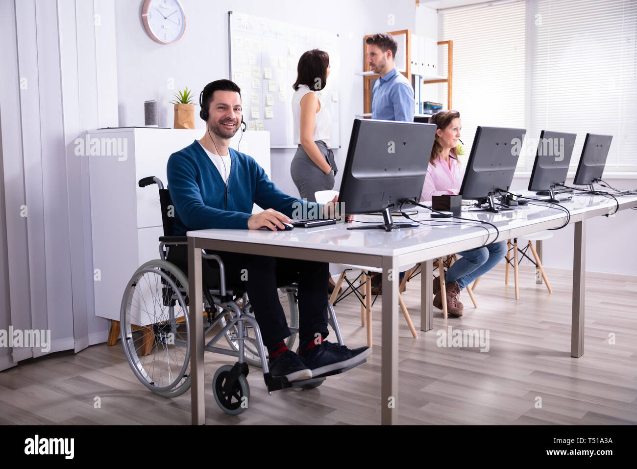 Man sitting desk in wheelchair hi-res stock photography and images - Alamy