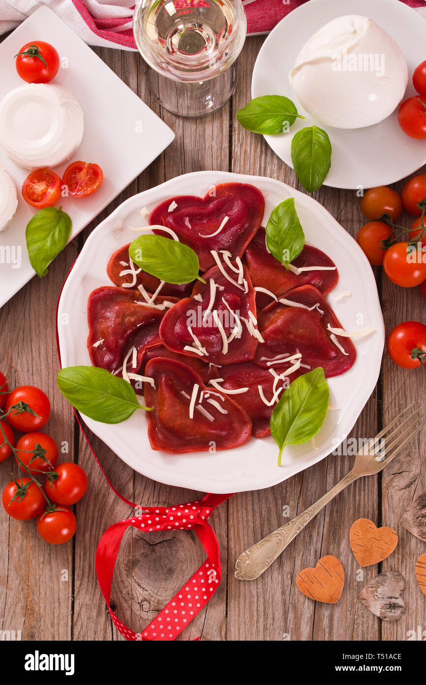 Red heart ravioli with tomato, mozzarella and basil Stock Photo - Alamy