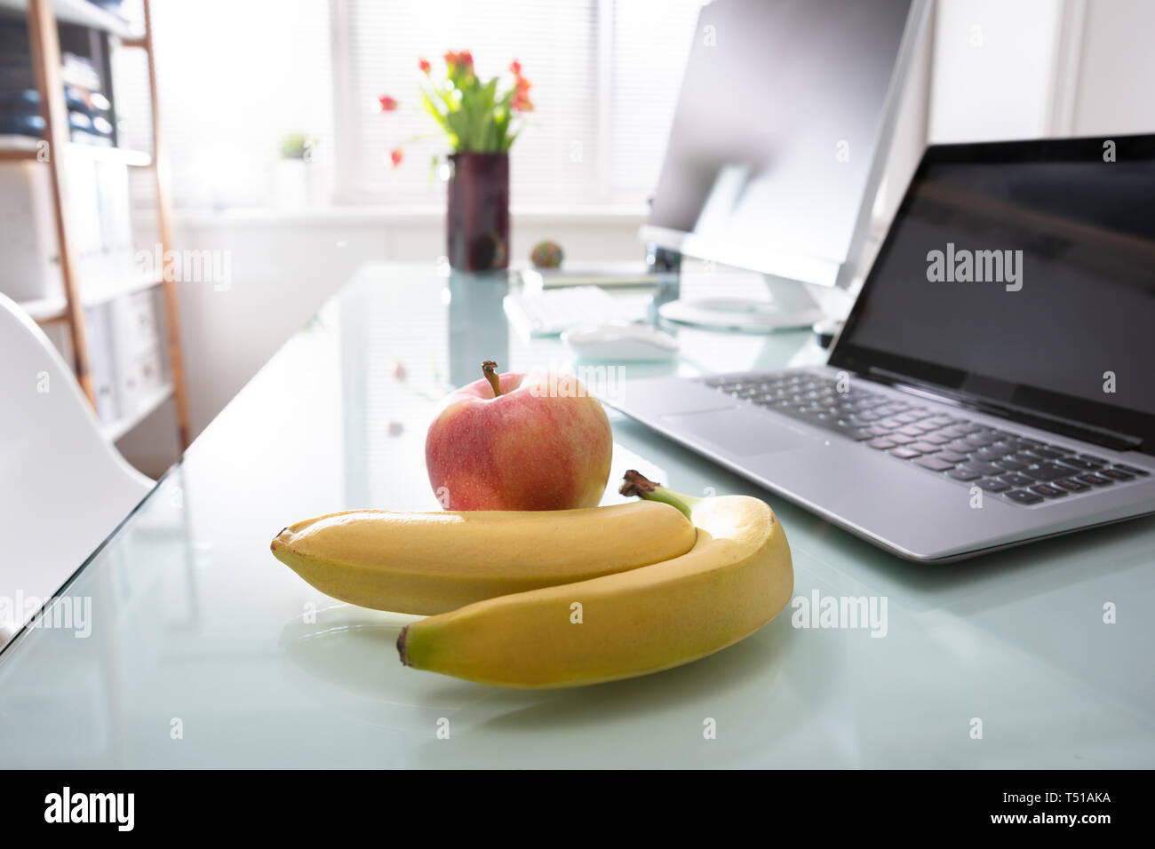 Apple And Laptop On Desk In Office Stock Photo - Alamy