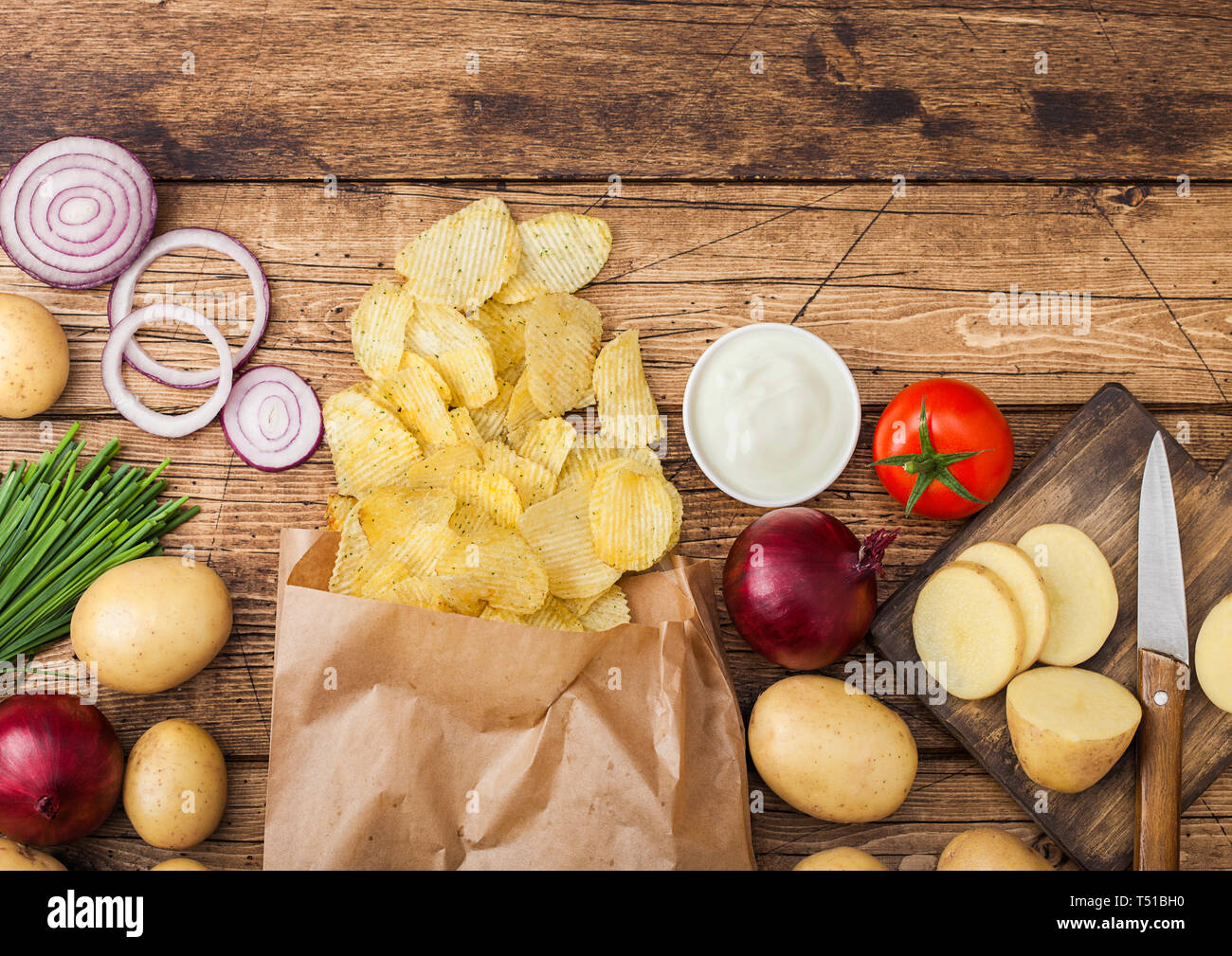 Fresh organic homemade potato crisps chips with sour cream and red ...