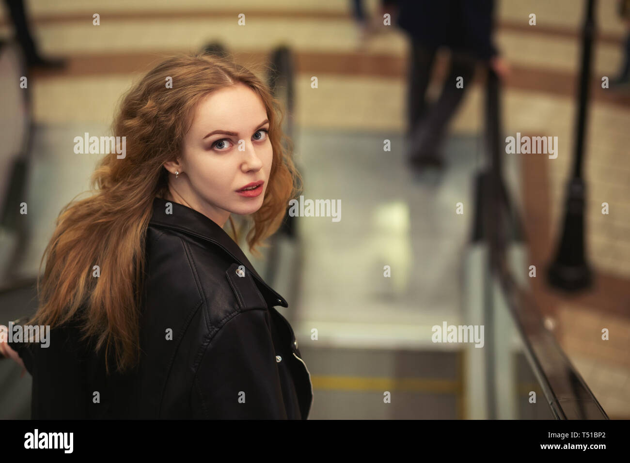 scared beautiful blond curly young woman looking back, standing on ...
