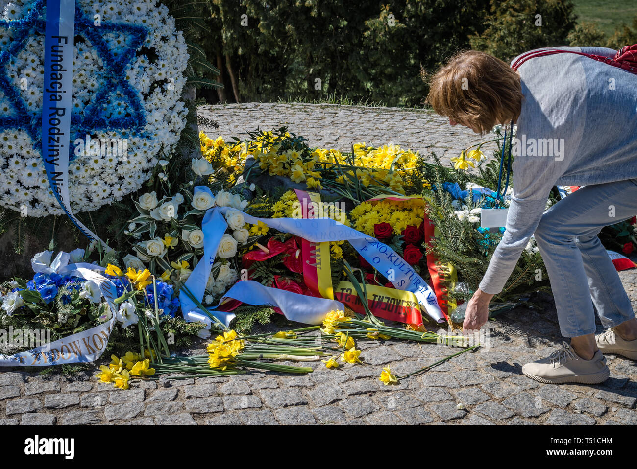 Warsaw, Poland - April 19th, 2019: Woman lays flowers in front of the ...