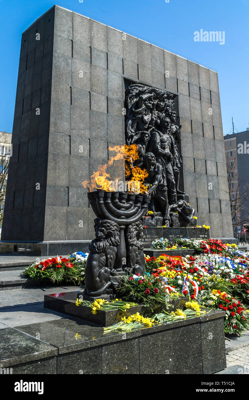 Menorah with burning flame in front of the Warsaw Ghetto Heroes ...