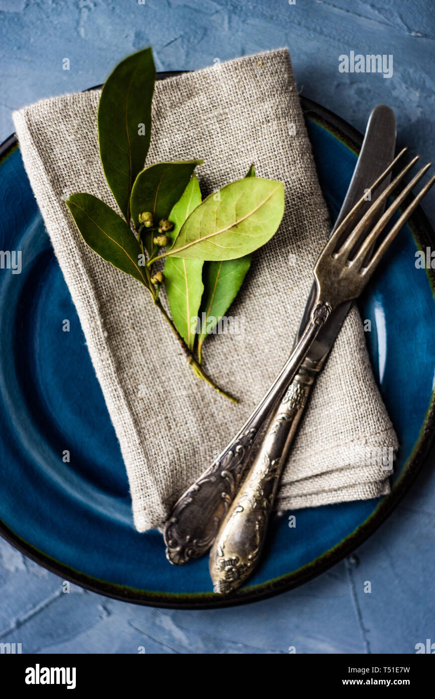 Rustic table setting with bay laurel leaves on wooden table with copy ...