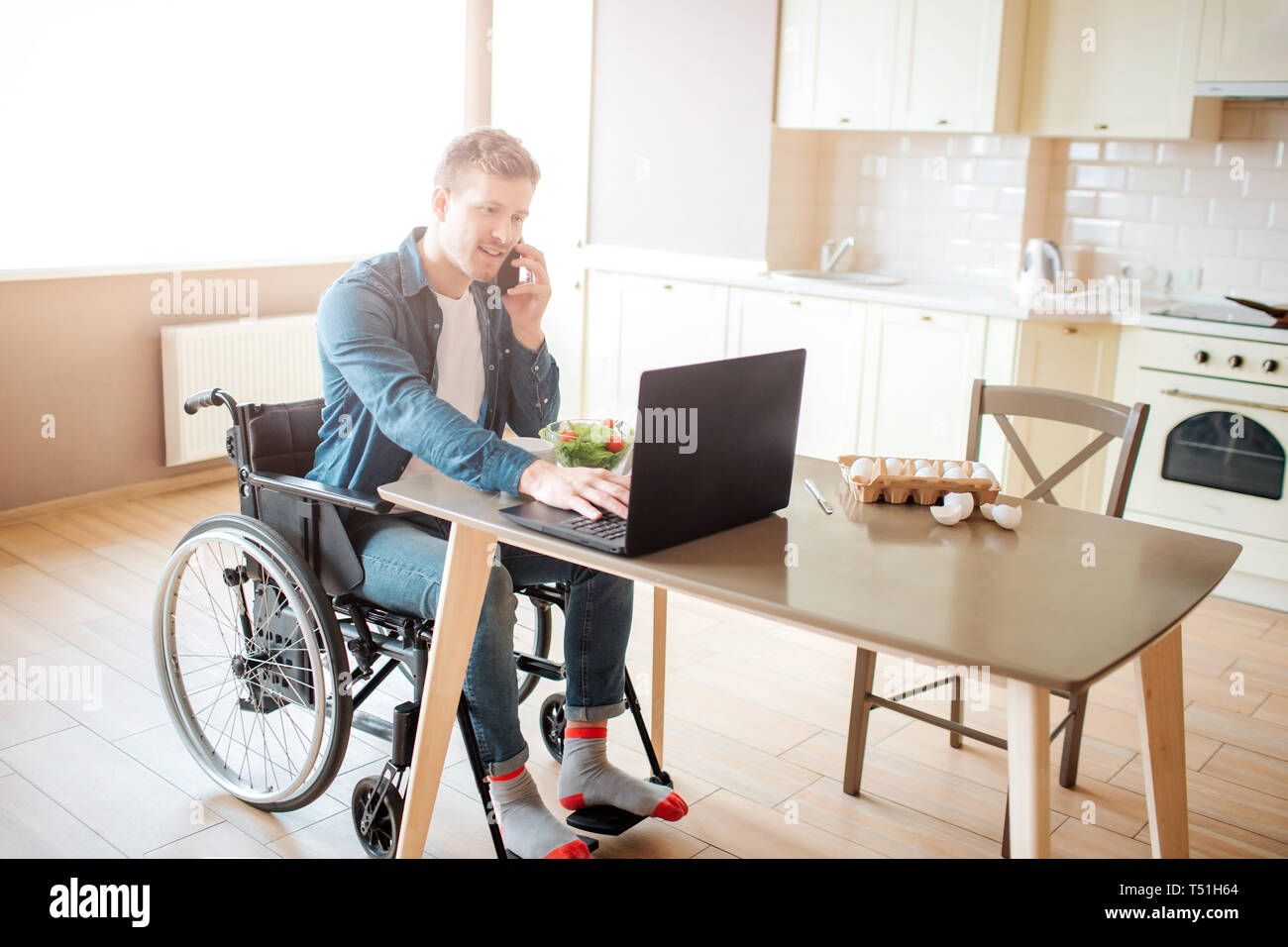 Young worker with disability and special needs sit at table and work ...