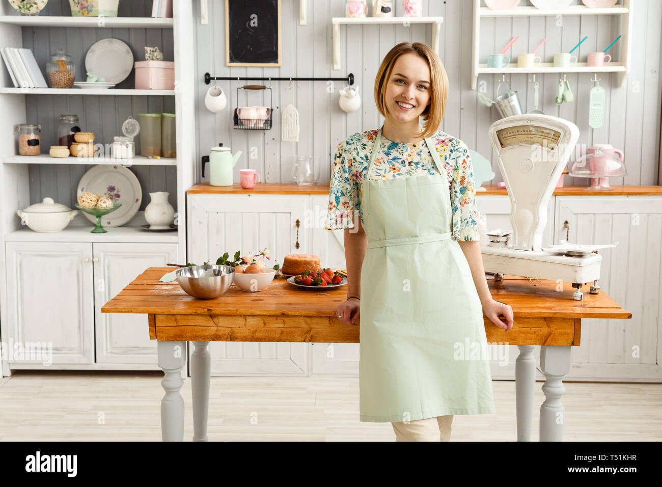 Attractive girl in an apron smiles in the kitchen Stock Photo - Alamy