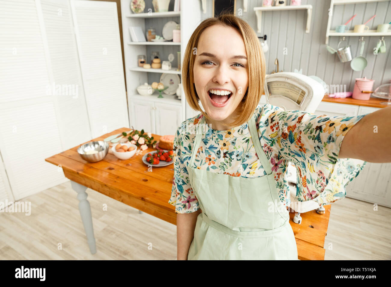 A joyful girl in the kitchen makes selfie Stock Photo - Alamy