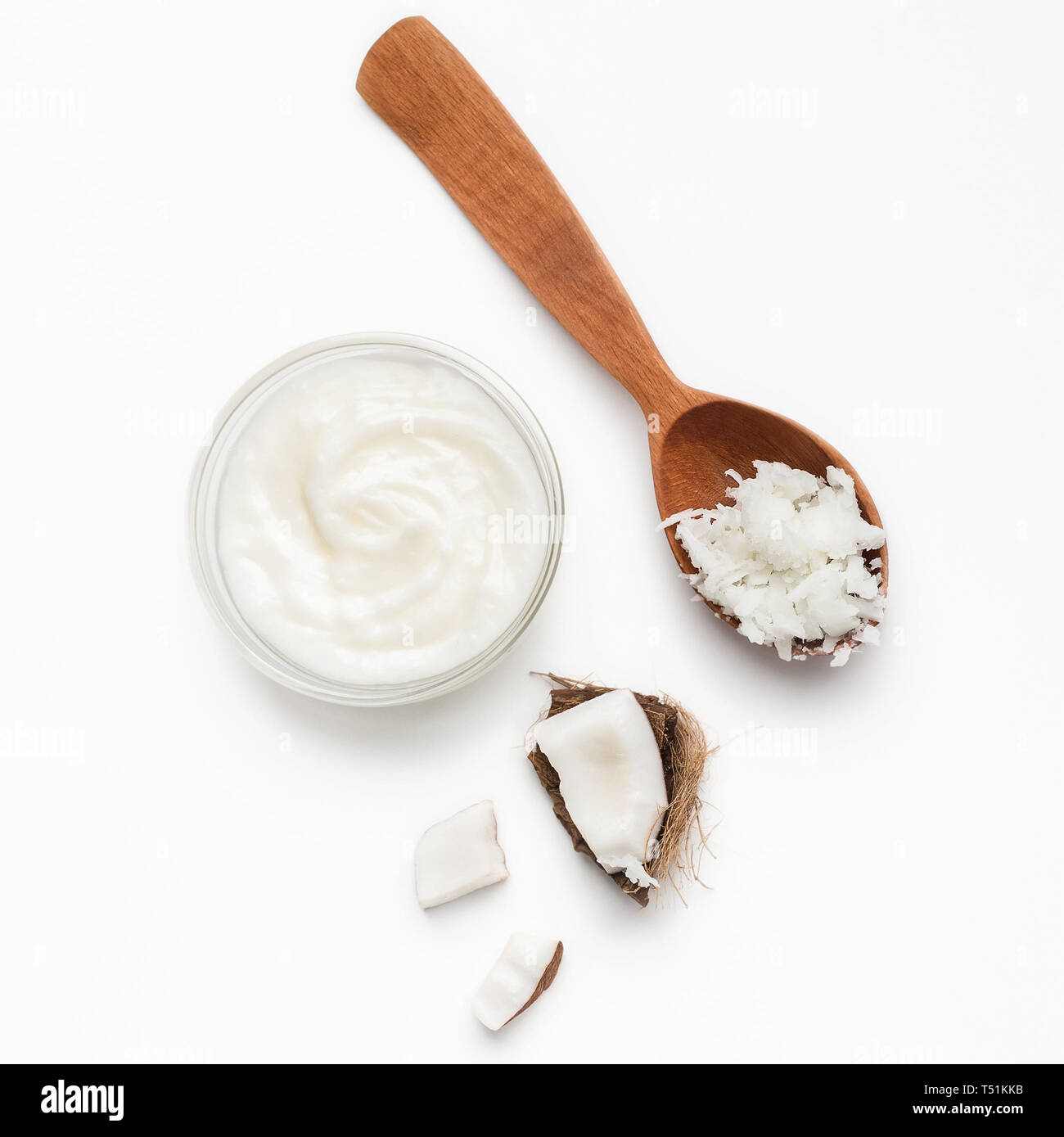 Coconut flesh in wooden spoon, bowl of coco butter and pieces of coco ...
