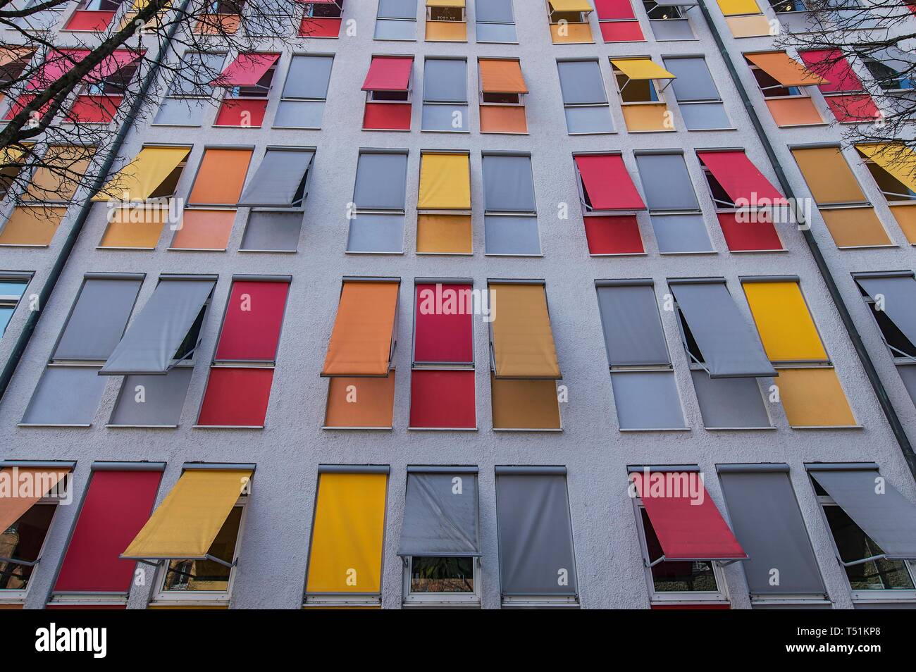 Facade of a residential building with colourful roller blinds, Munich ...