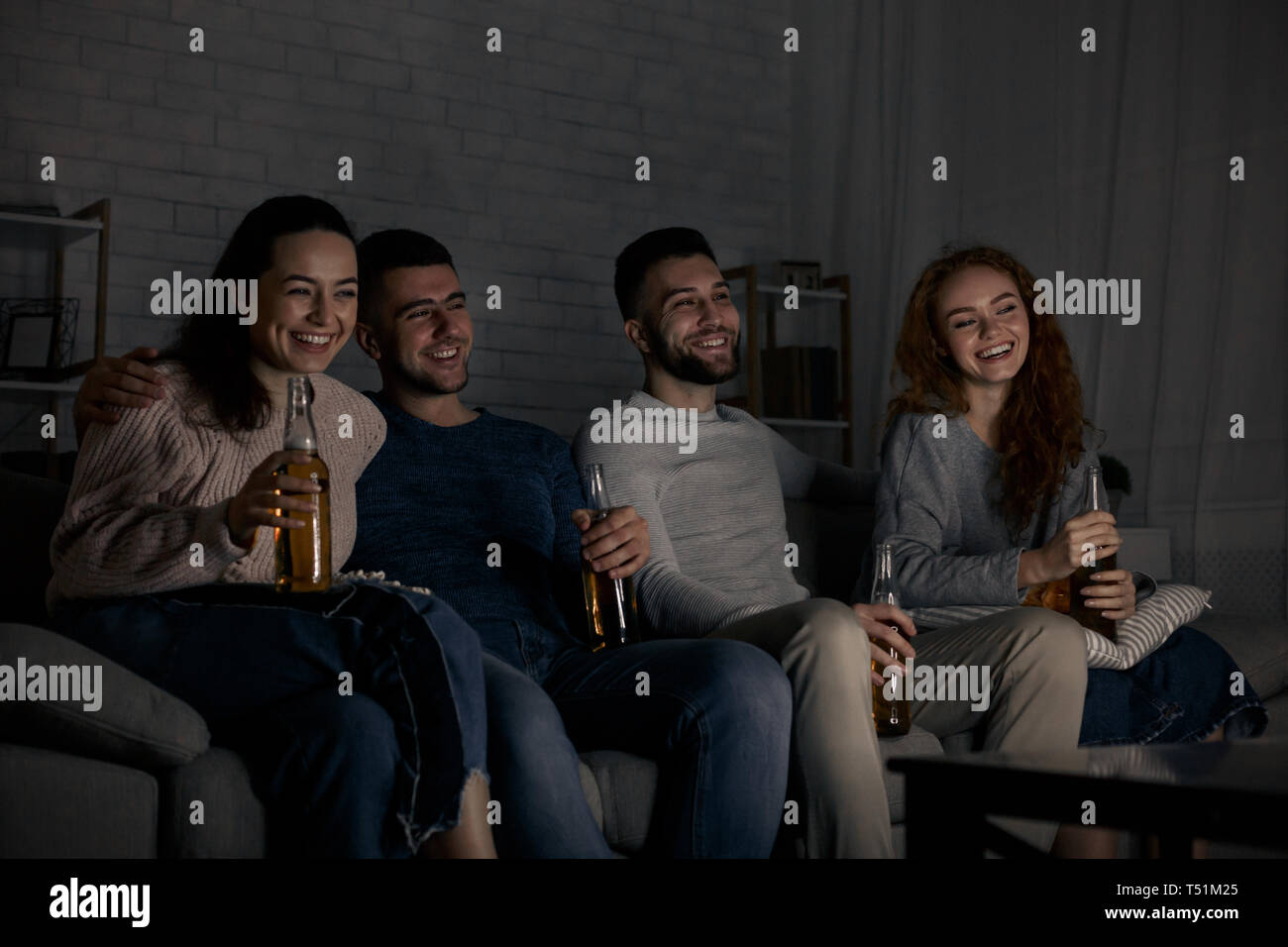 Comedy film. Happy friends watching movie at home Stock Photo - Alamy