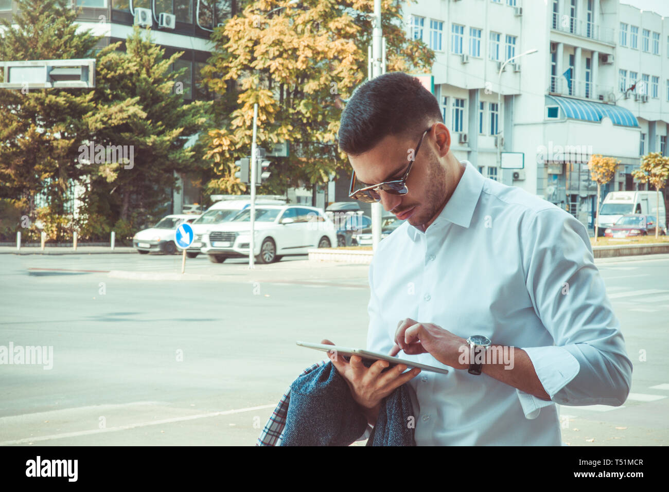 Business guy wearing white shirt is smiling and holding tablet Stock ...