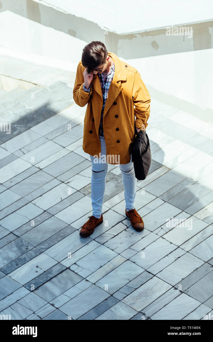 Confident businessman holding briefcase and talking on cellphone in city center Stock Photo - Alamy