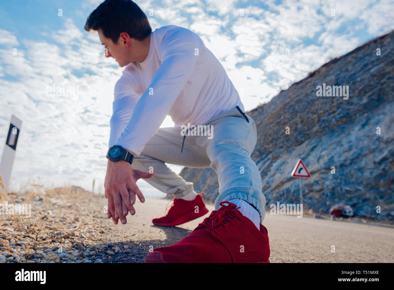Bodybuilder performing his stretching routine in the morning on an ...