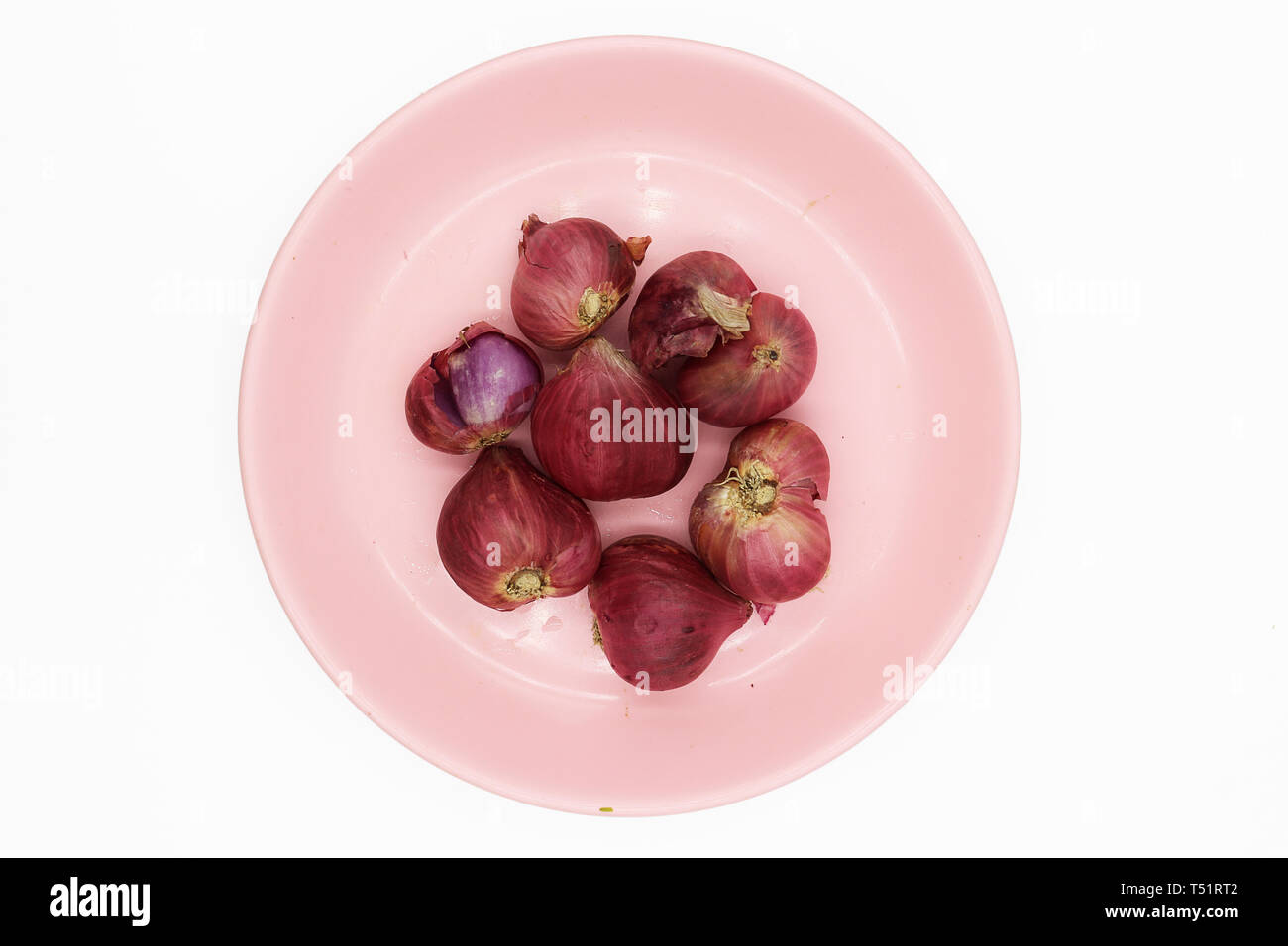 Shallot in pink dish on white background Stock Photo - Alamy