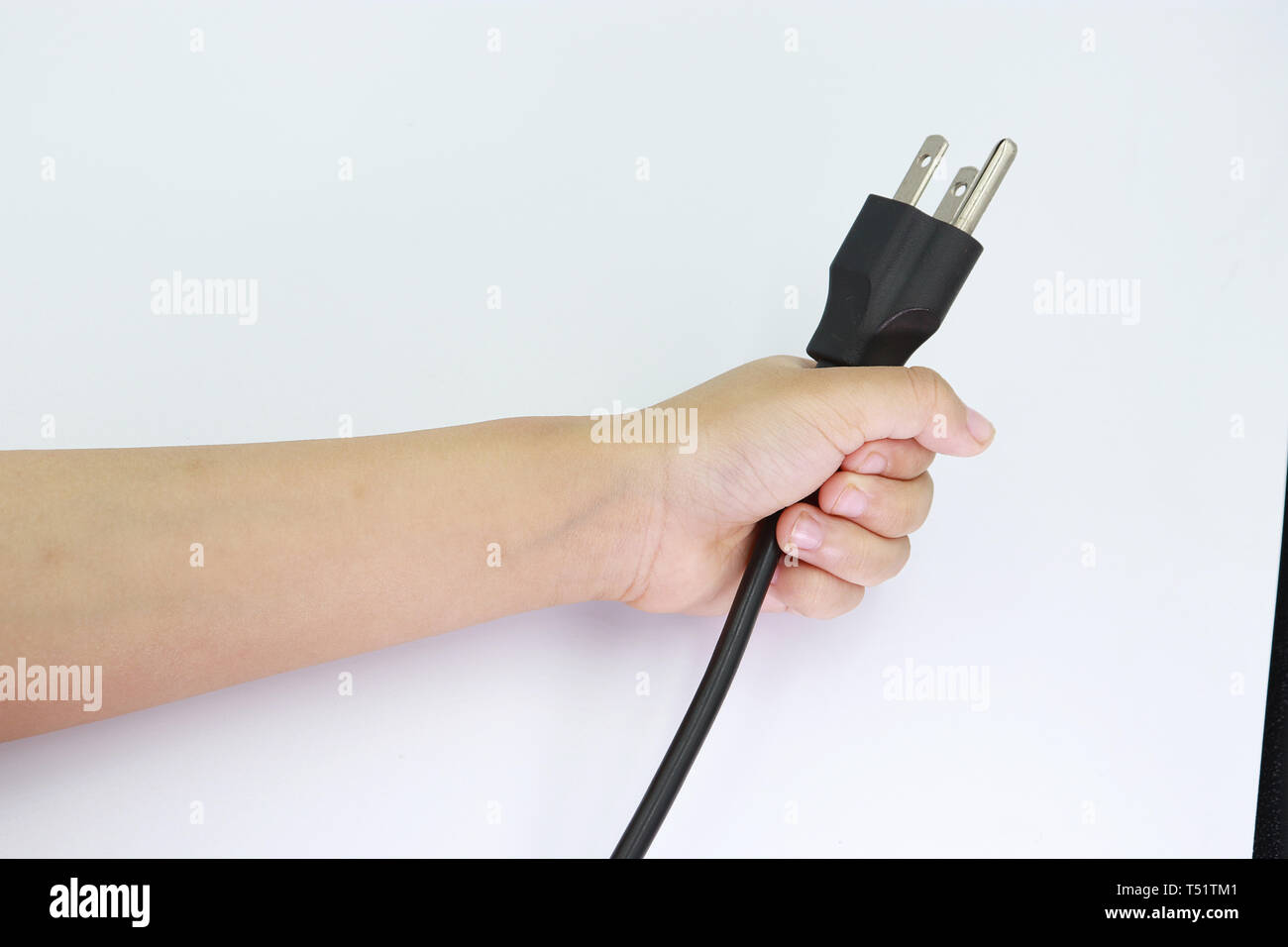 Electric plug in kid hand on white background Stock Photo - Alamy