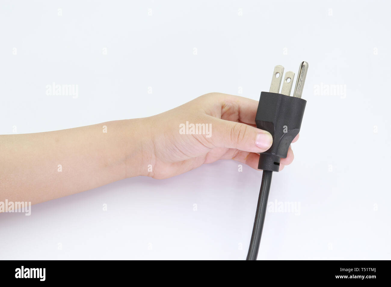 Electric plug in kid hand on white background Stock Photo - Alamy
