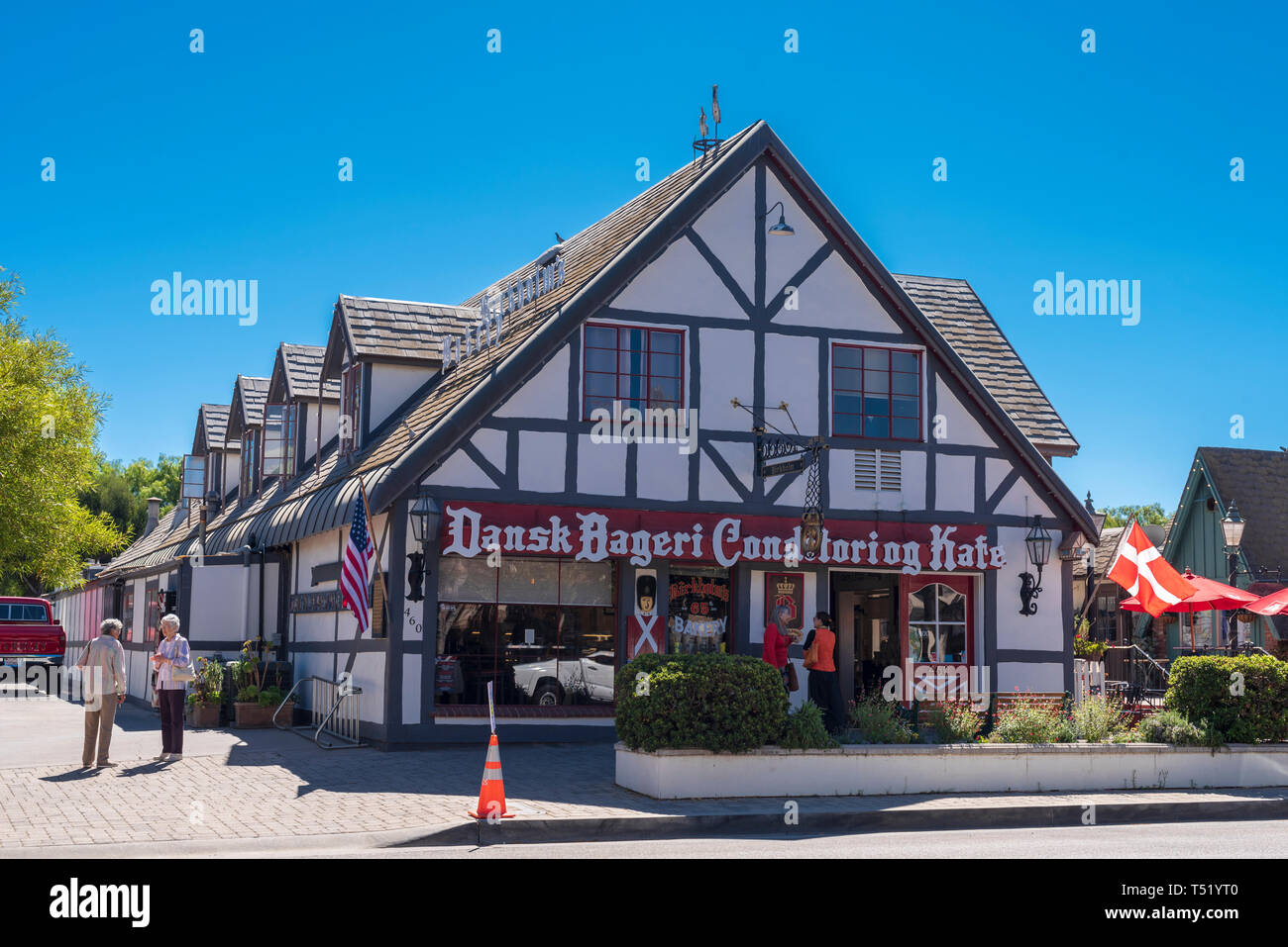 Looking across street at tourists and small town bakery shop under a ...