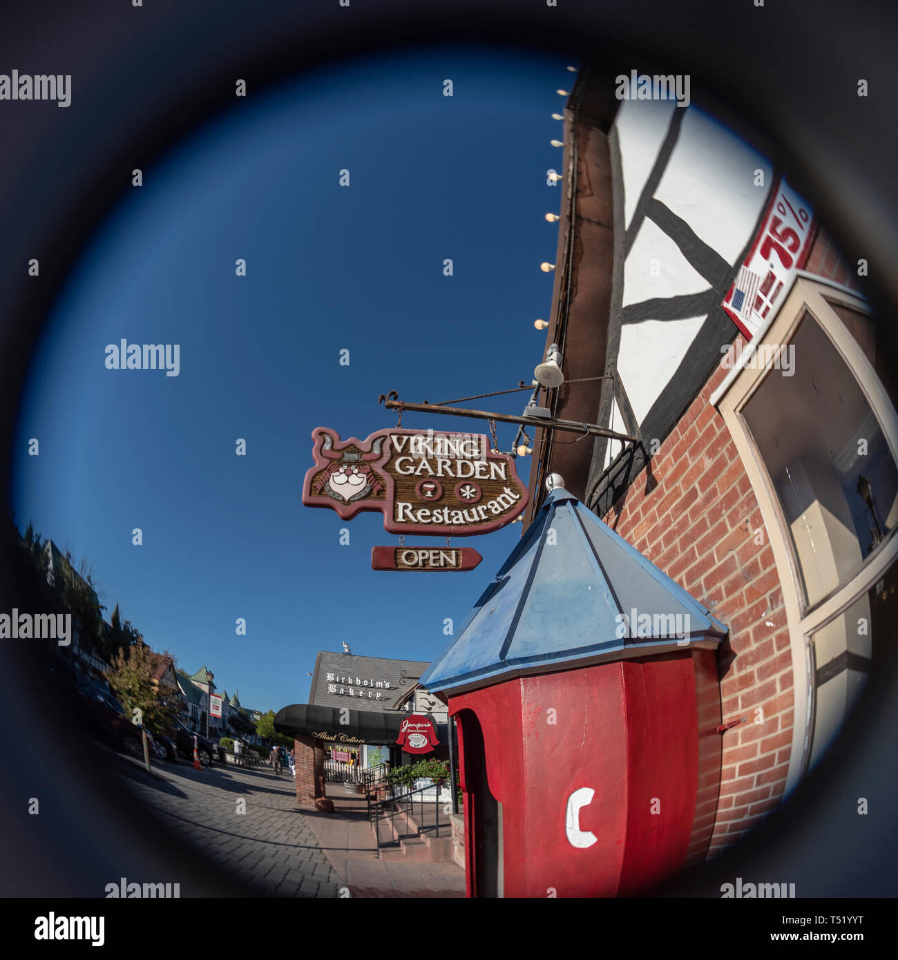 Wide angle view including business sign and telephone booth next to ...