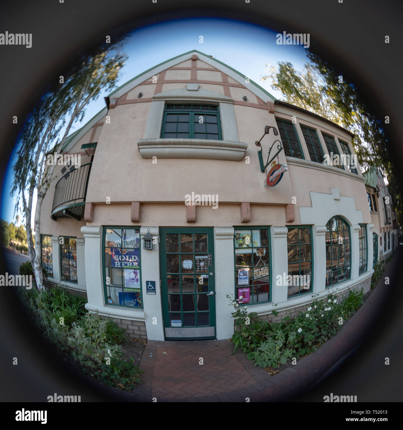 Corner store front with green doors, tow story building and balcony ...
