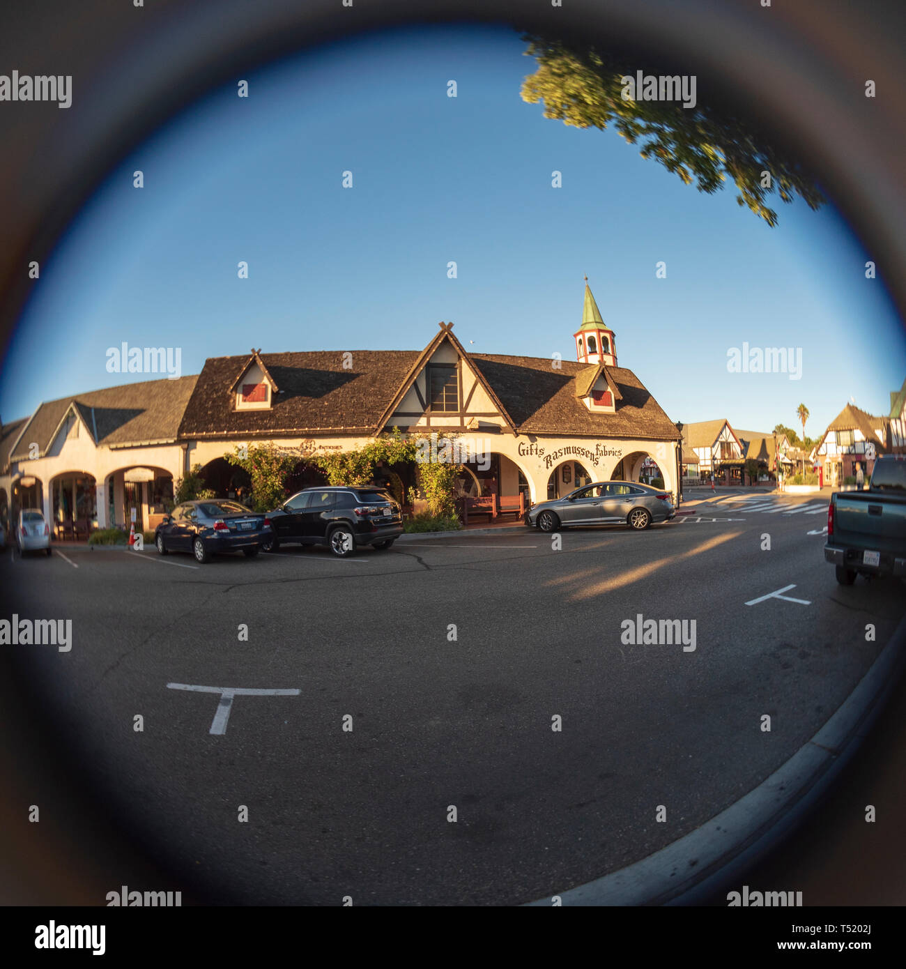 Ultrawide angle view of small town street with cars and building with ...