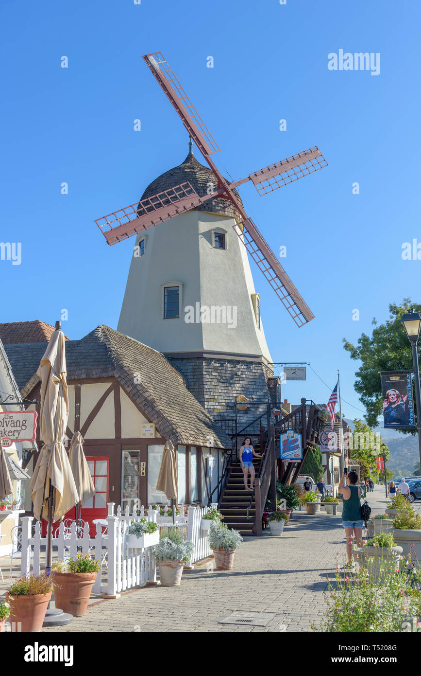 Windmill style building on small town street with two tourists Stock ...