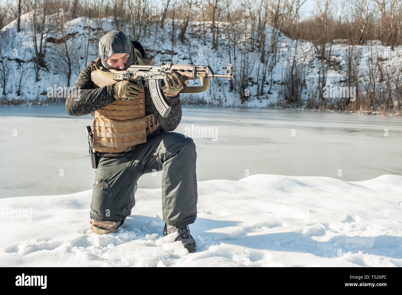 Army soldier in crouching position shooting from rifle machine gun on ...