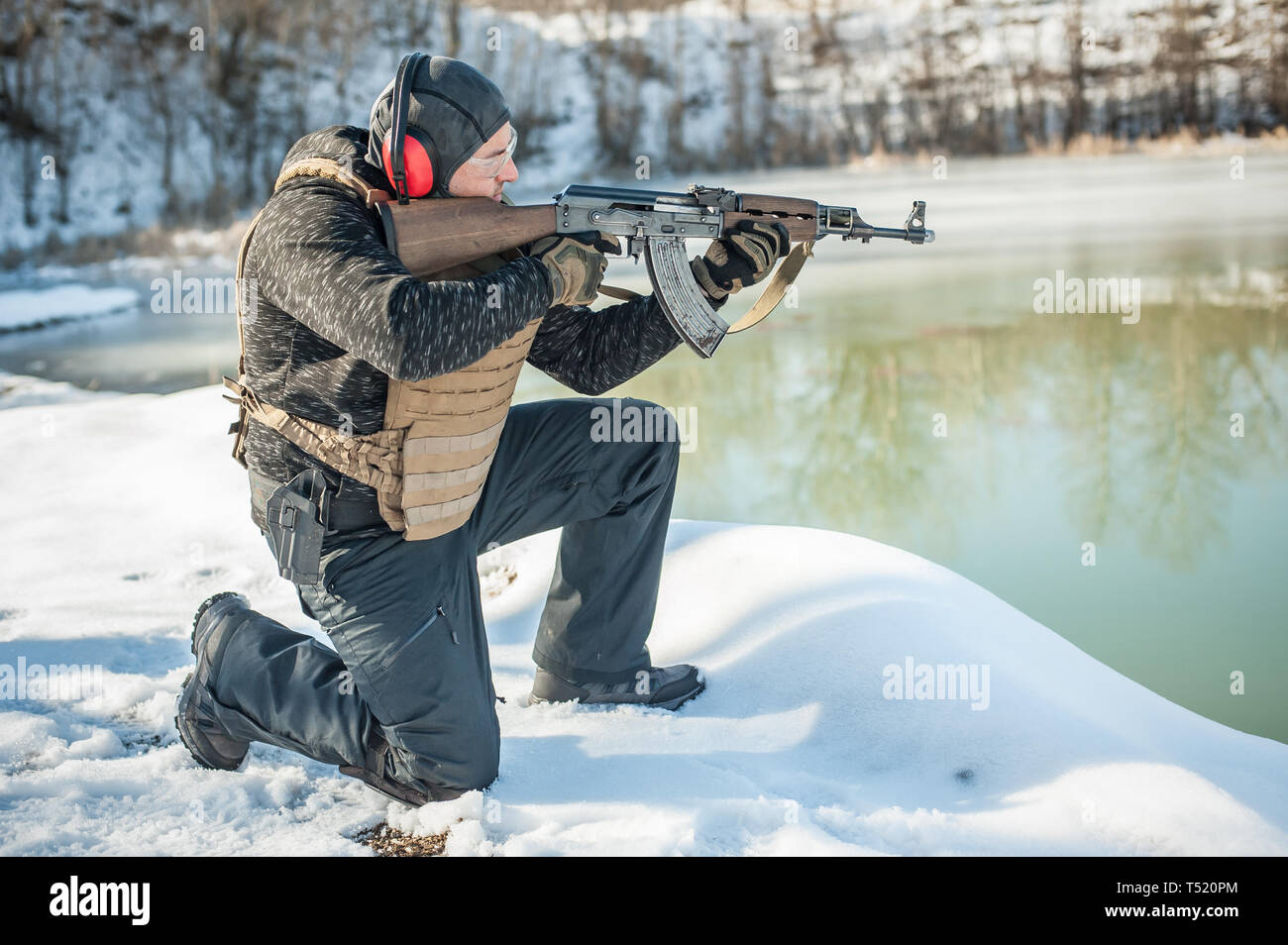 Army soldier in crouching position shooting from rifle machine gun on ...
