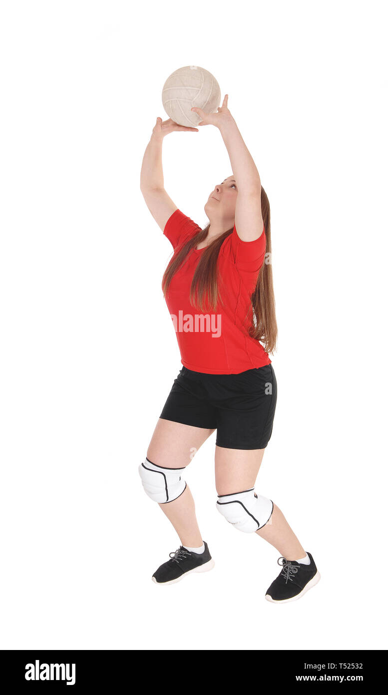 A young teenage girl standing in the studio catching the ball over her ...