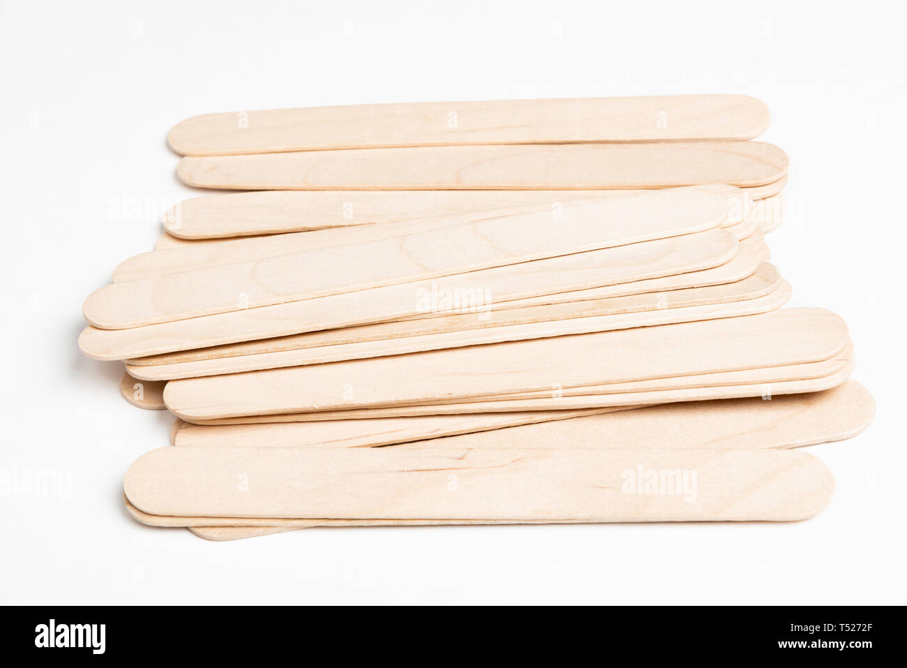A stack or array of unused thick wooden craft sticks set on a plain ...