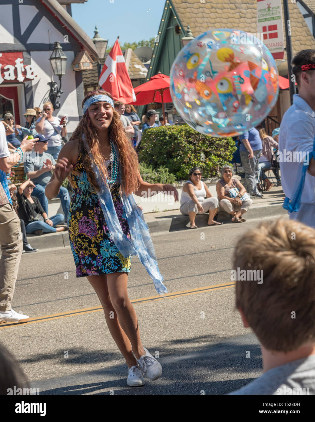 Girl dancing in parade, long brown hair, colorful dress, white shoes ...