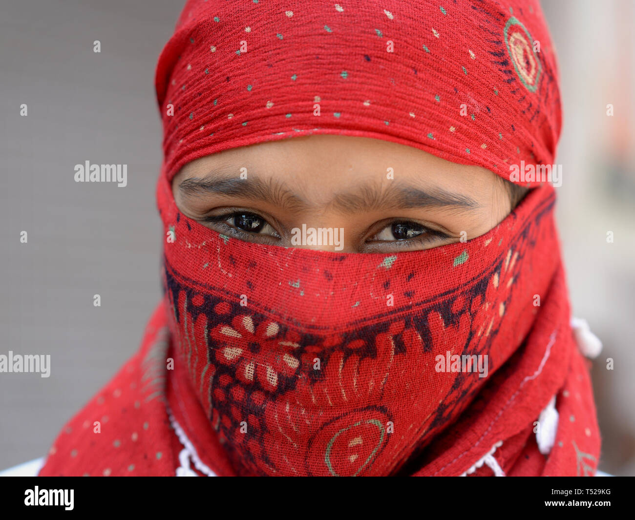 Young Indian Rajasthani woman with romantic eyes covers her face with a ...