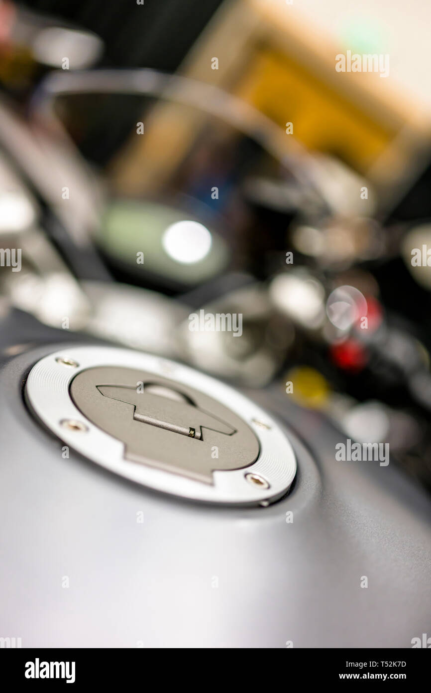 The compact fuel tank cap of a sports bike in the focus of the camera ...