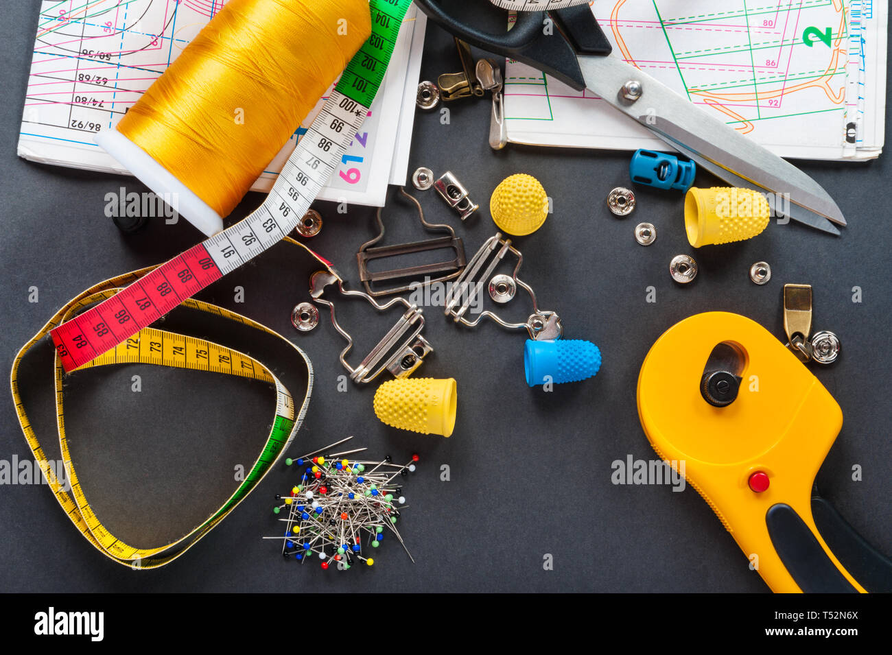 sewing tools thread with scissors and measuring tape on dark Stock ...