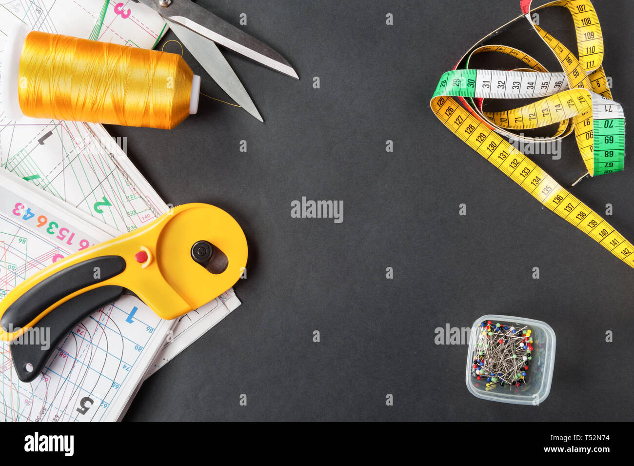 sewing tools thread with scissors and measuring tape on dark Stock ...