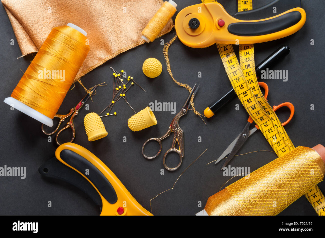 sewing tools thread with scissors and measuring tape on dark Stock ...
